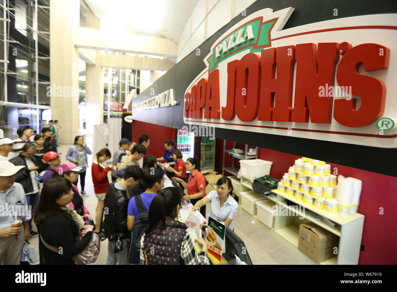 --FILE--Customers queue up in front of a stall of Papa John's Pizza ...