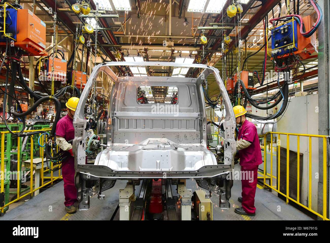 --FILE--Chinese workers assemble a truck on the assembly line at the ...