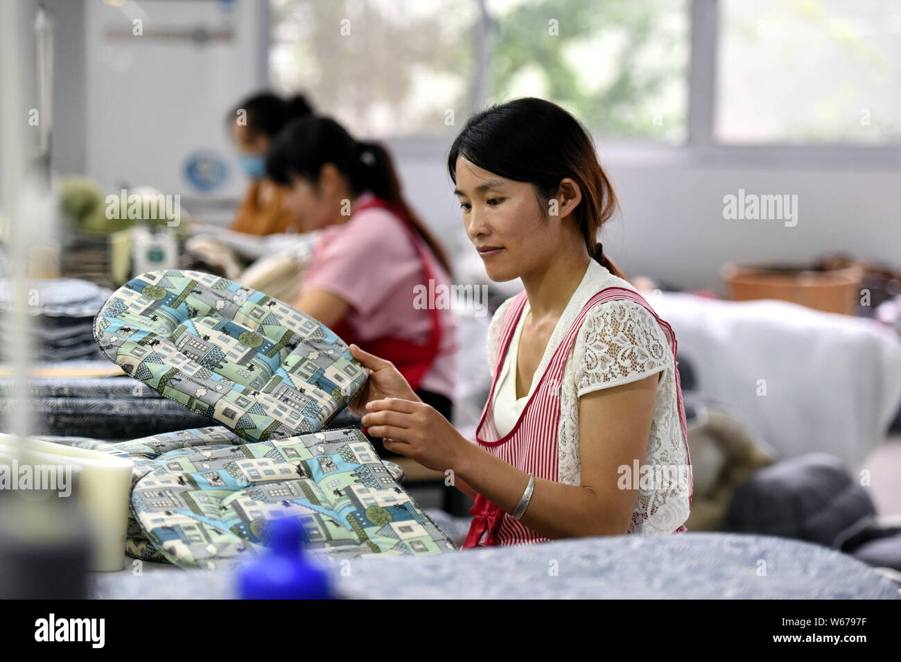 Chinese female workers process fabric doghouses to be exported at a ...