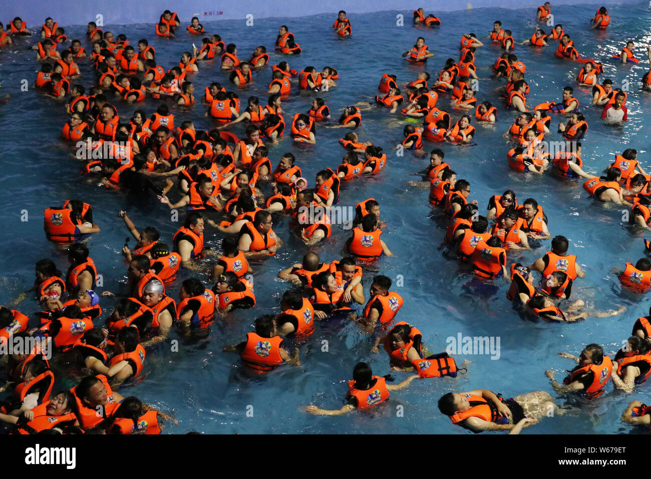 Aerial view of a swimming pool crammed with Chinese holidaymakers on a ...