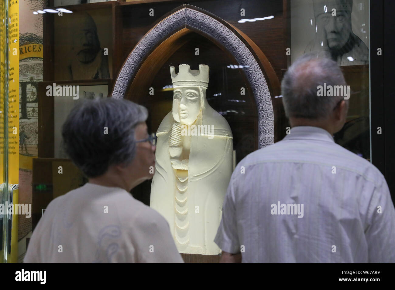Passengers look at a reproduction of the Lewis Chessmen "Queen" from ...