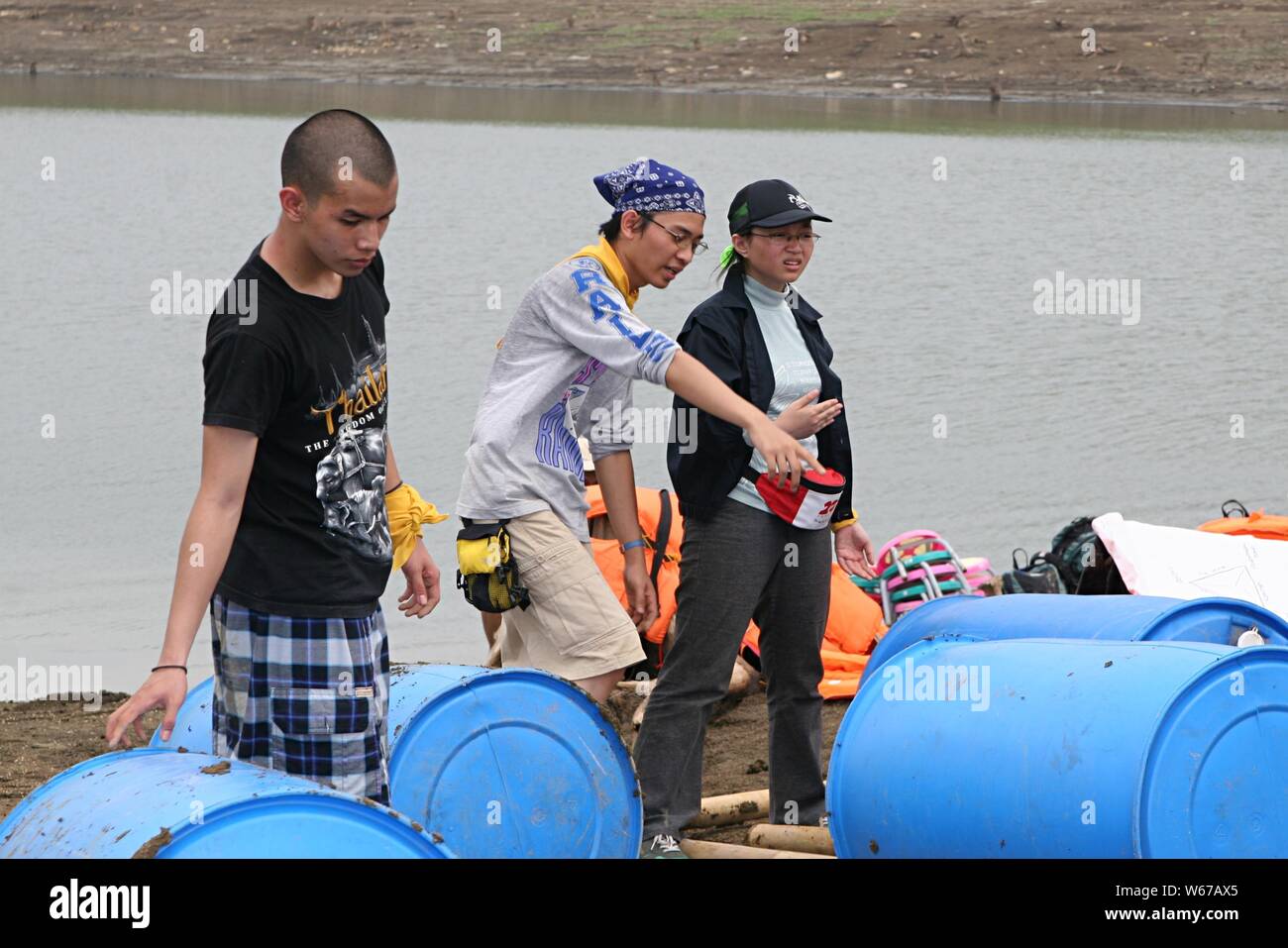 A young man is pointing his finger when leading his team make a boat ...