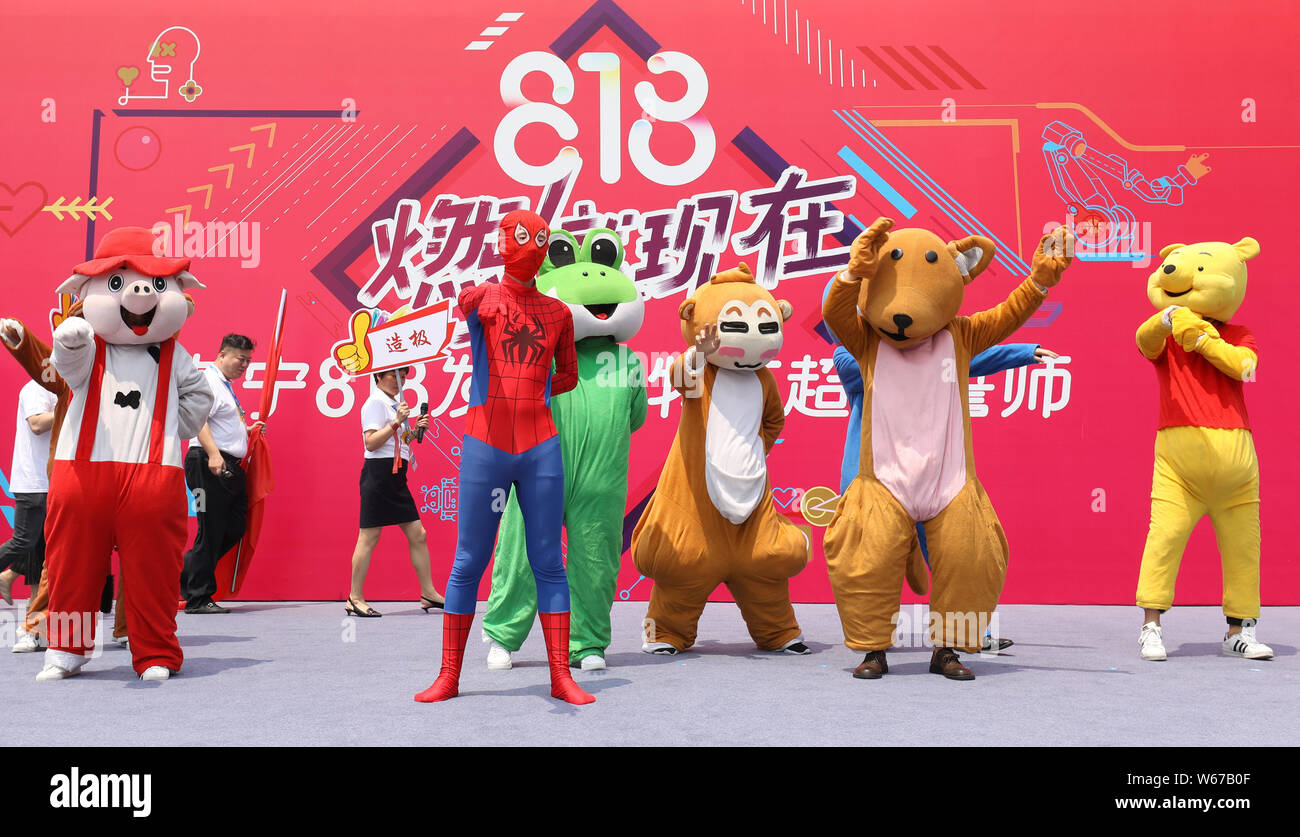 Chinese employees dressed in cartoon costumes perform during an oath ...