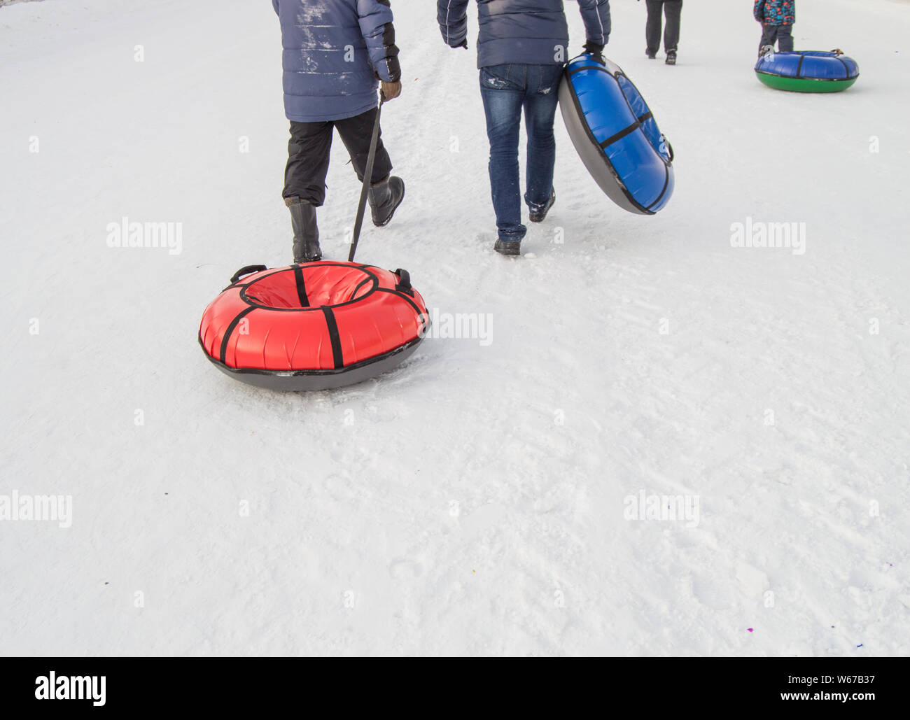 Children dragged sleds tubing to ride a roller coaster in city Park in ...