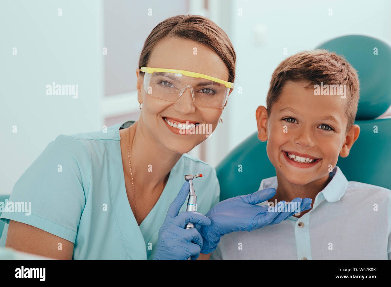 Dentists and her little patient positive smiling at camera after ...