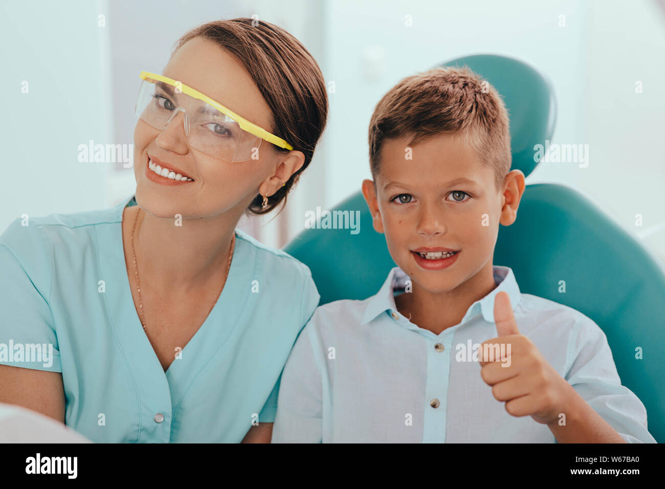 Dentists and her little patient positive smiling at camera after ...