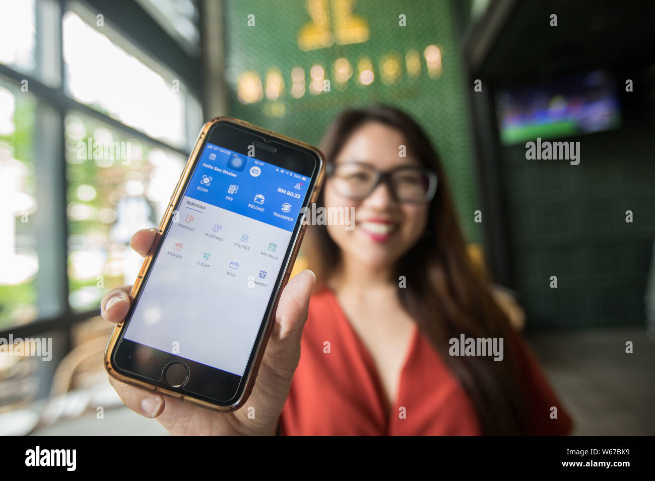 A customer shows the mobile e-wallet payment service Touch&Go operated ...