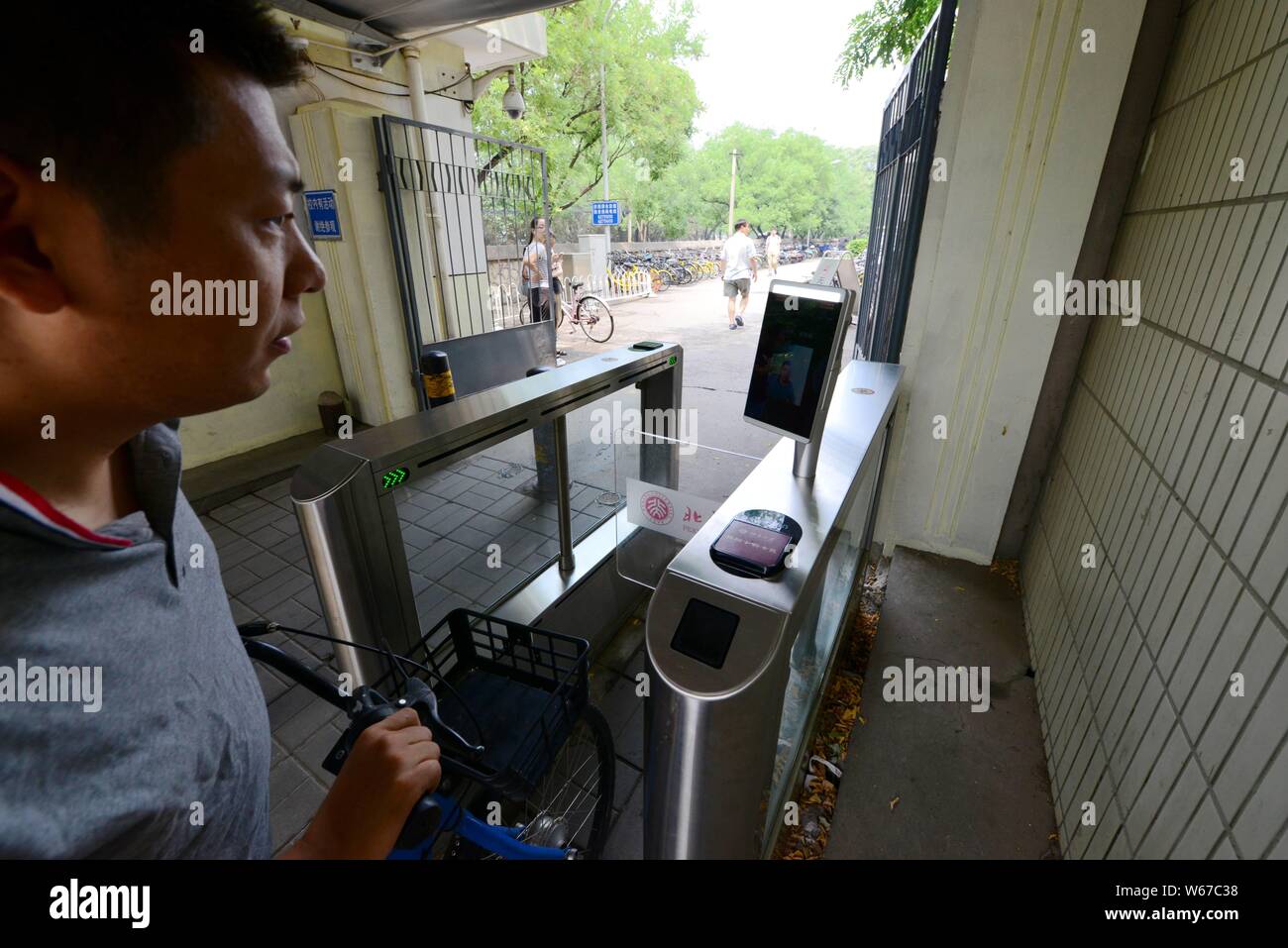 A student scans his face through a facial recognition system to enter a ...