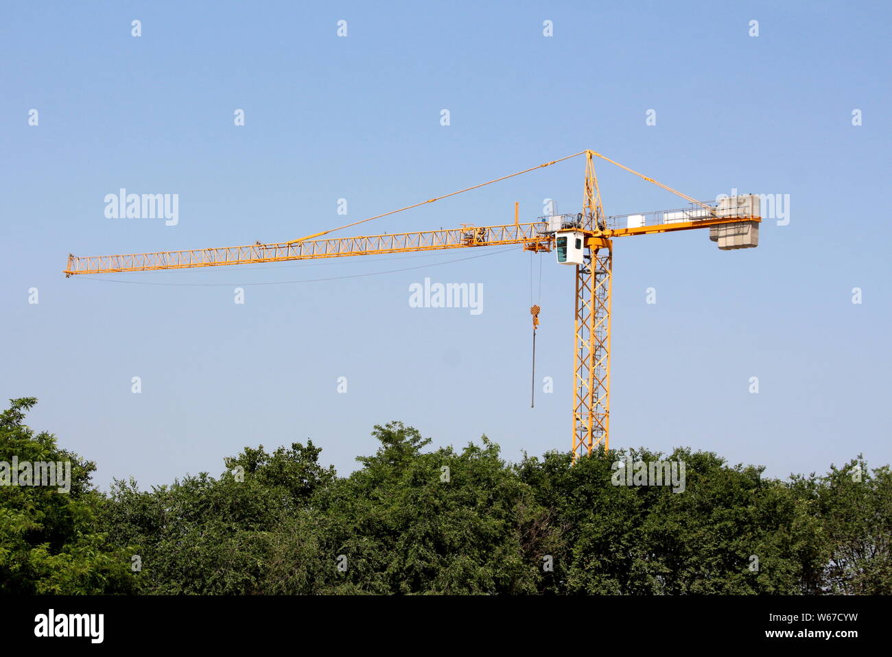 Construction industry tower crane or TC rising high over construction ...