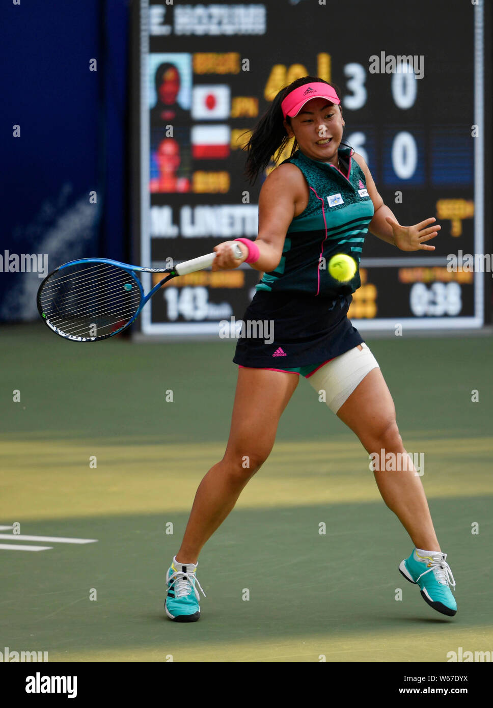 Eri Hozumi of Japan returns a shot to Madga Linette of Poland in their ...