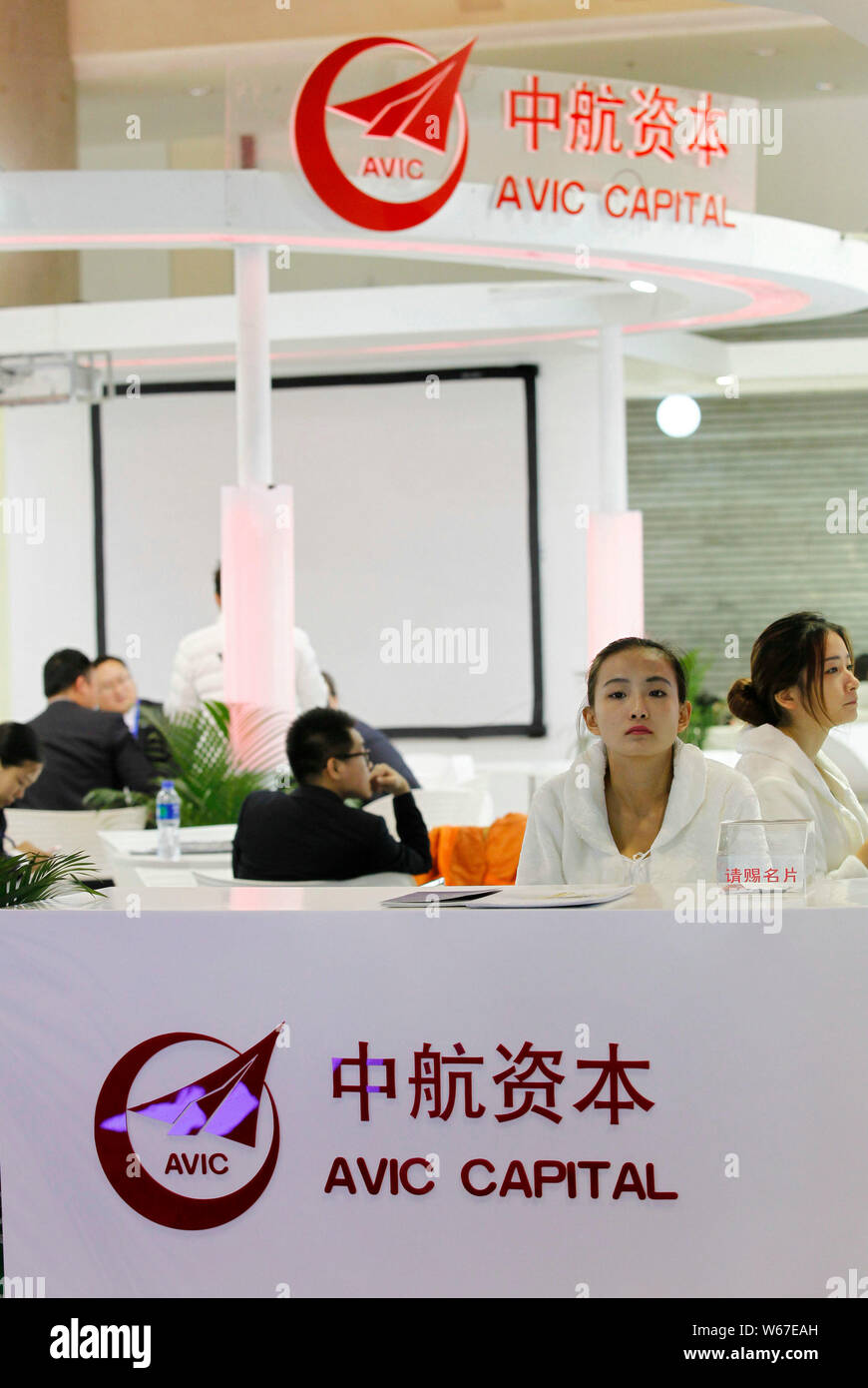 --FILE--Chinese employees are seen at the stand of AVIC Capital of AVIC ...