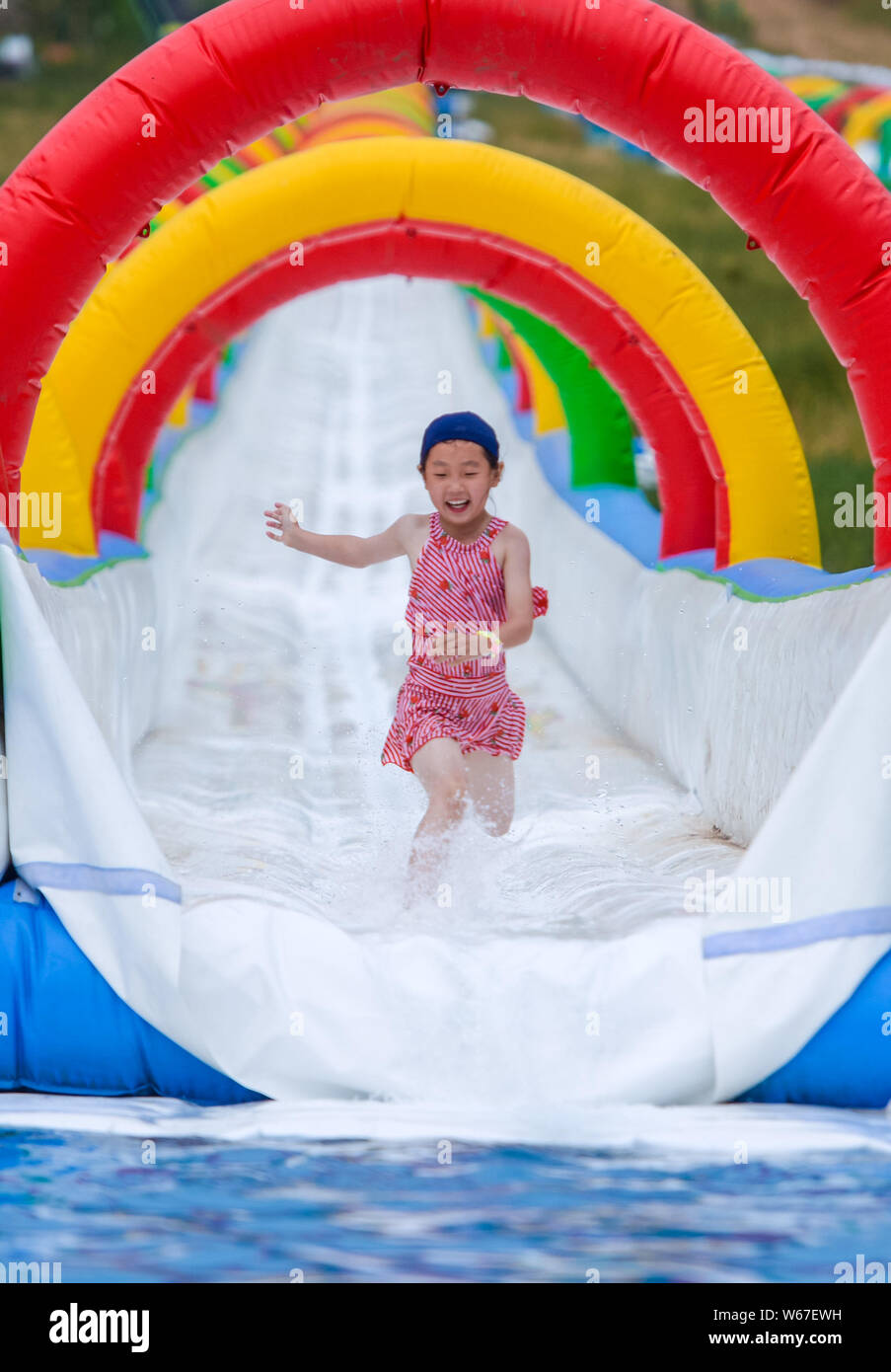 A tourist plays on Asia's longest water slide at Jingzhihu Resort in ...