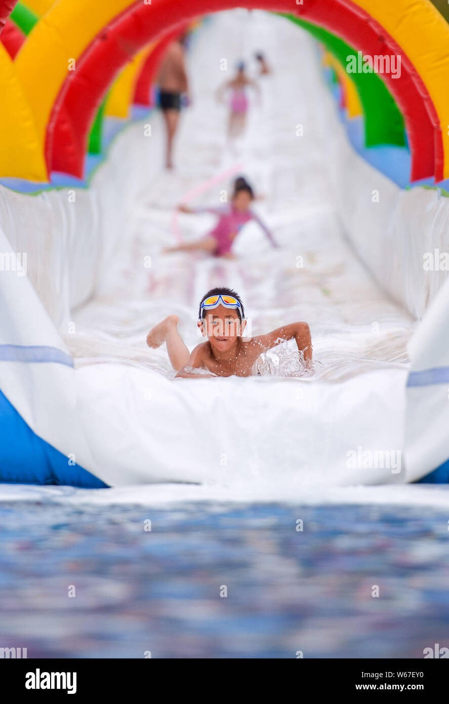 Tourists play on Asia's longest water slide at Jingzhihu Resort in ...