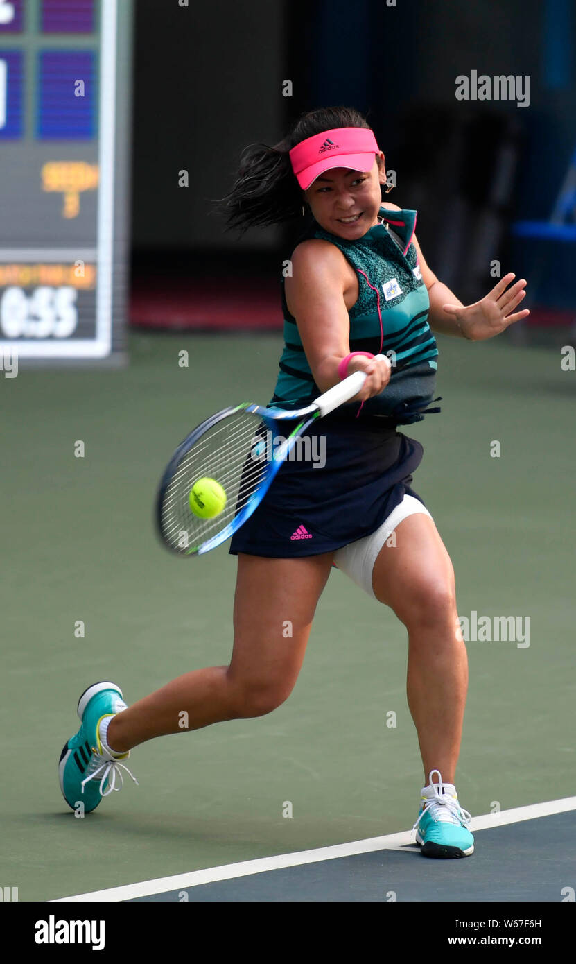 Eri Hozumi of Japan returns a shot to Madga Linette of Poland in their ...