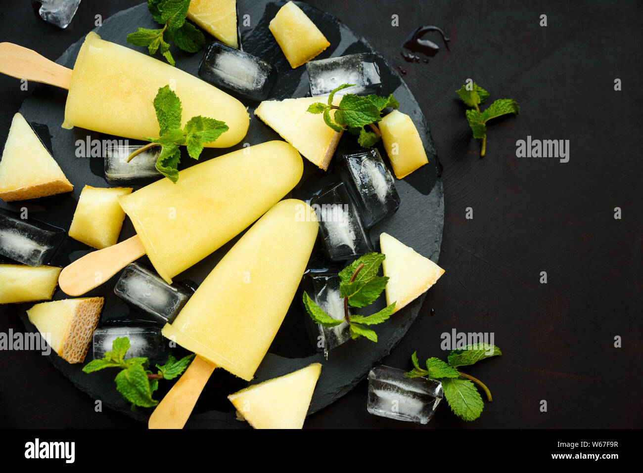 Homemade melon ice cream, pops or popsicles with ice, melon slices and ...