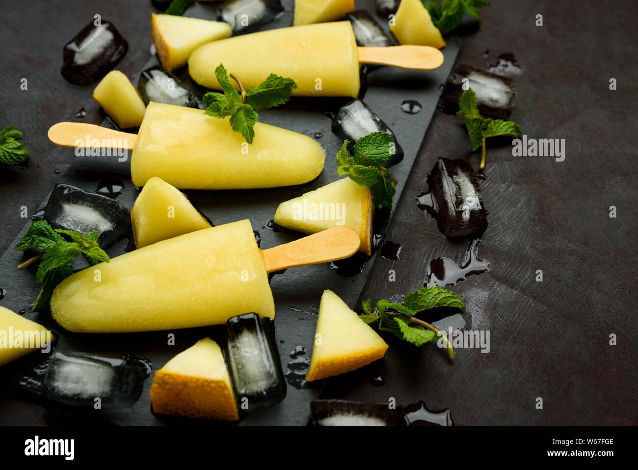 Homemade melon ice cream, pops or popsicles with ice, melon slices and ...
