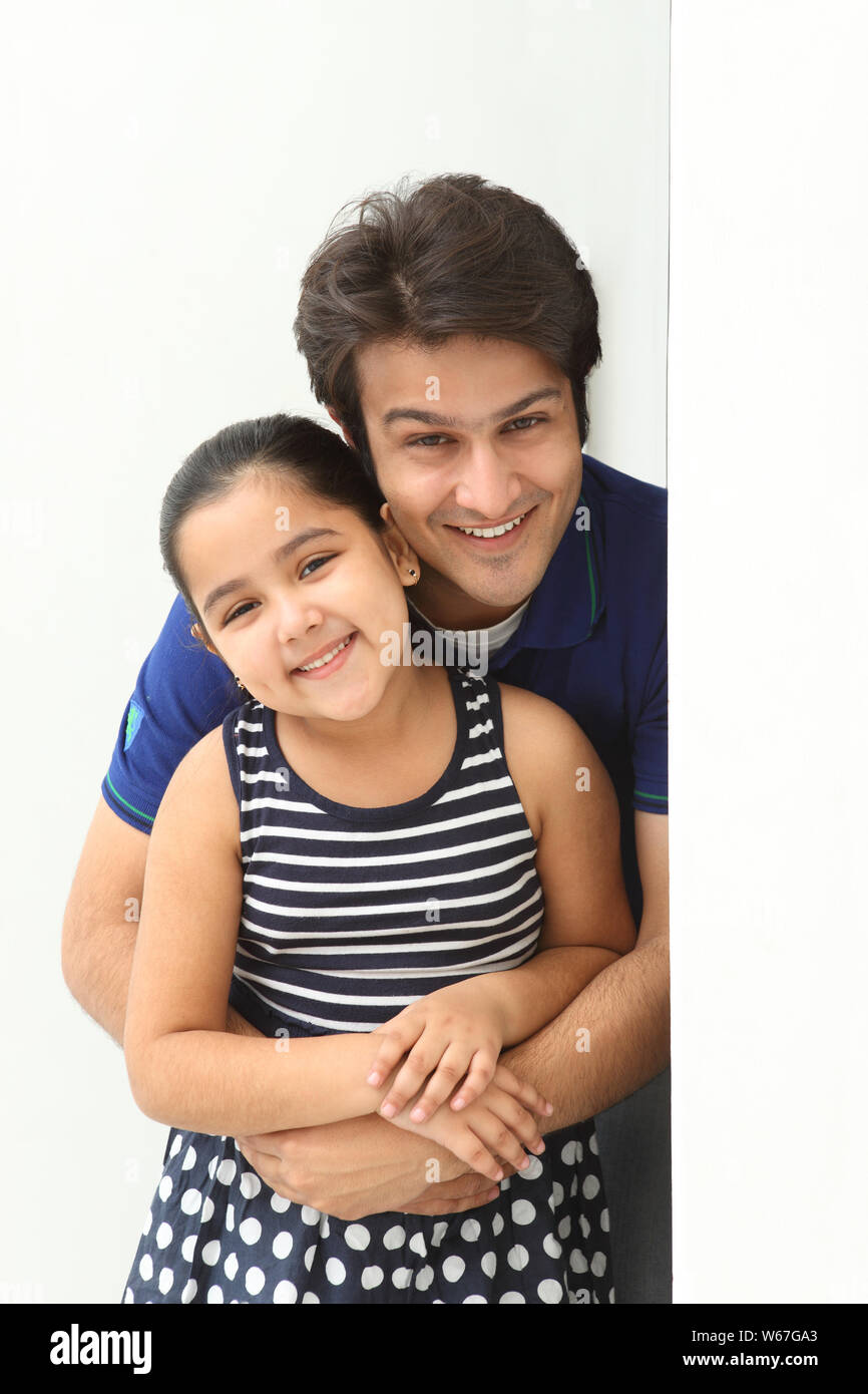 Man hugging his daughter and smiling Stock Photo - Alamy
