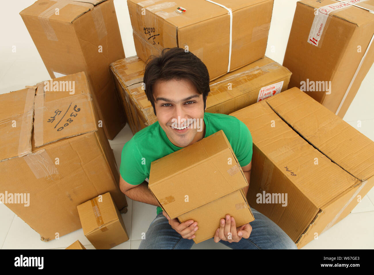 Man sitting with cardboard boxes Stock Photo - Alamy