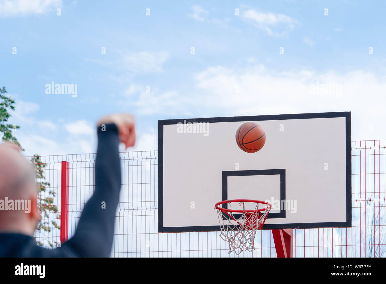 Attractive man playing basketball on basketball court. Man is out of ...