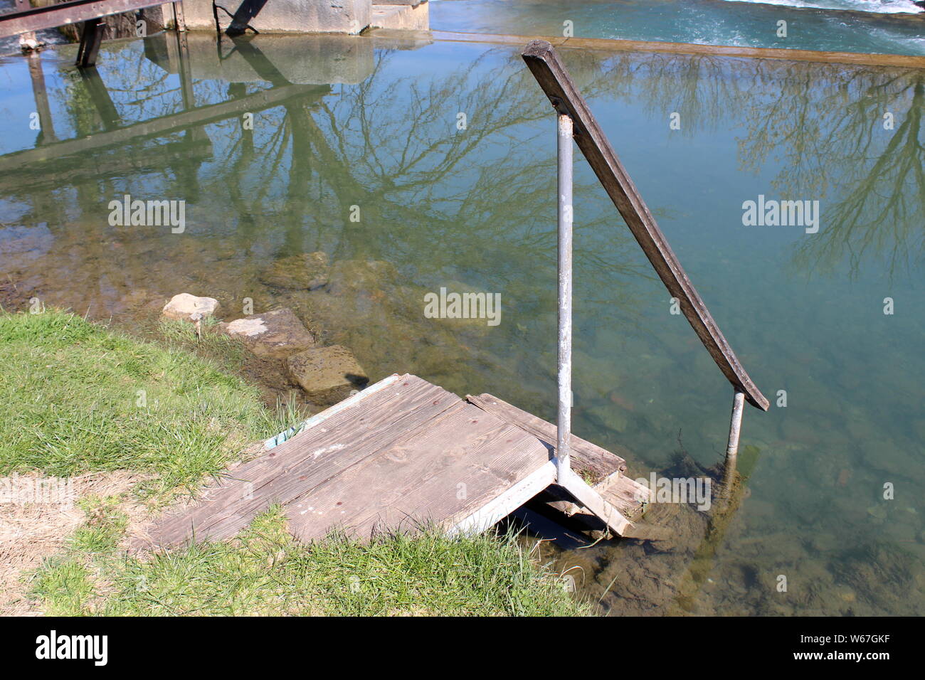Improvised homemade wooden steps with metal frame mounted on river bank ...