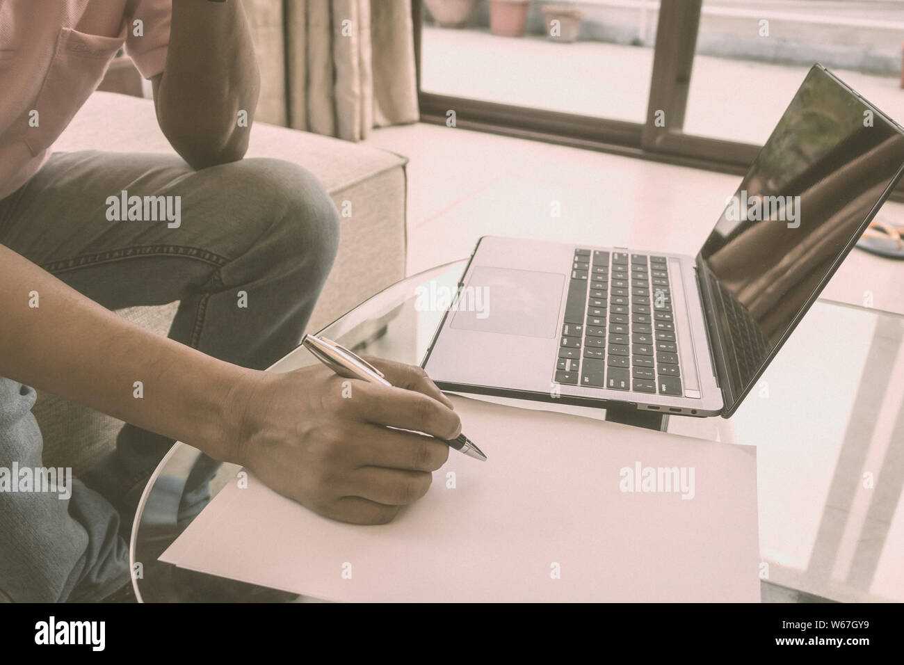 Anonymous Worker writing on a sheet of paper a business project work on ...
