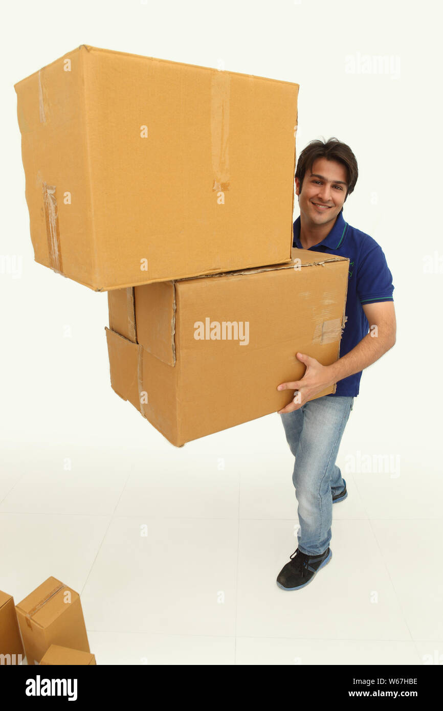 Man carrying cardboard boxes and smiling Stock Photo - Alamy