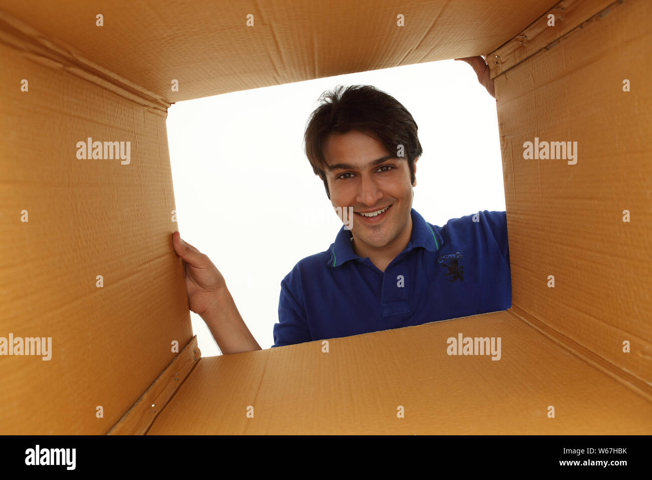 Man looking through cardboard box Stock Photo - Alamy