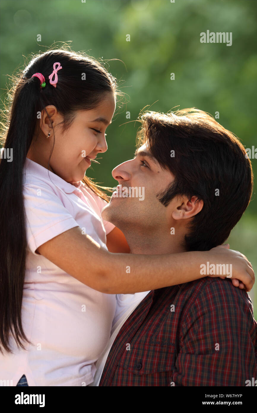 Man carrying his daughter smiling Stock Photo - Alamy
