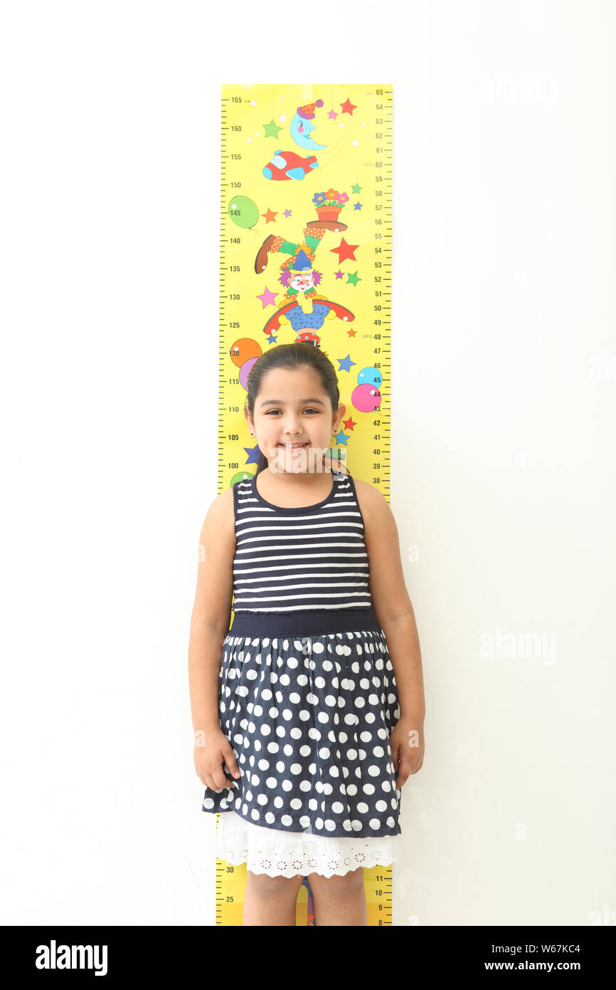 Portrait of a girl measuring her height Stock Photo - Alamy