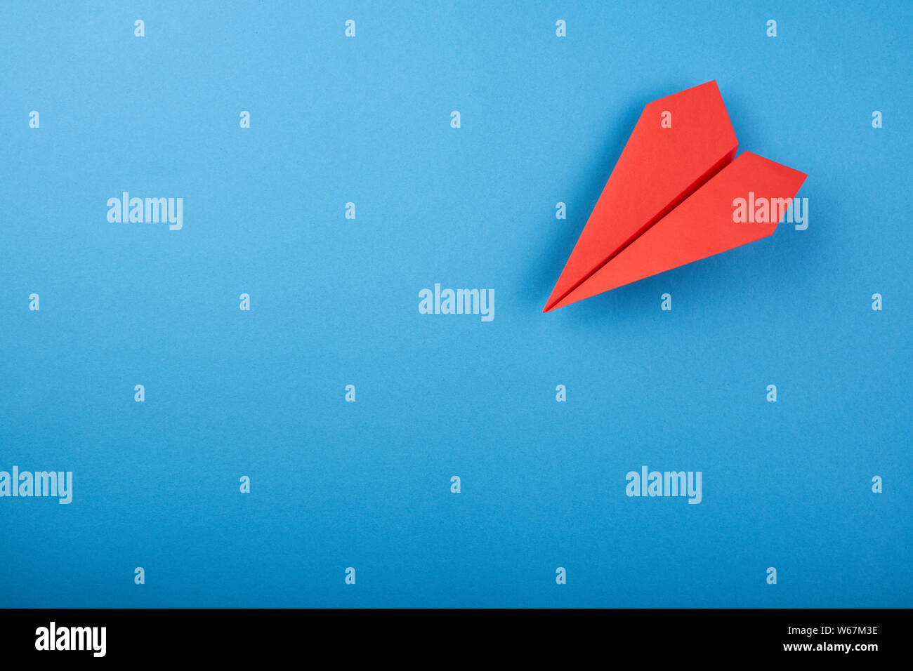 Red paper plane on the blue background Stock Photo - Alamy