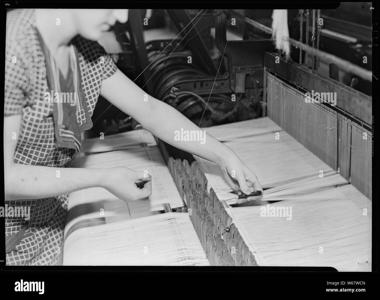 Paterson, New Jersey - Textiles. Threading broken warp thread through ...