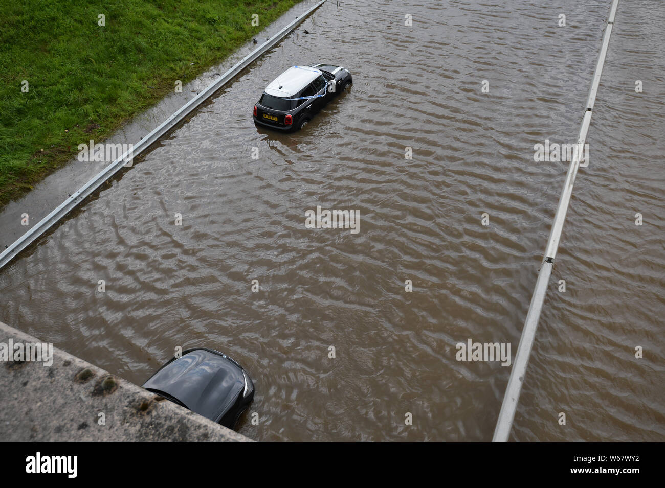 A car stranded in flood water on the A555 near Handforth, Greater ...