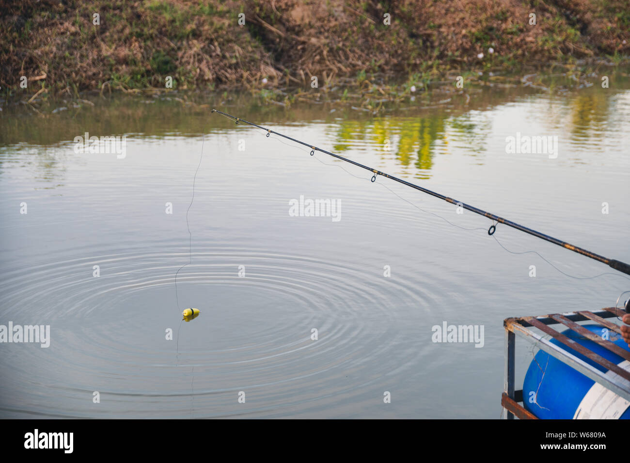 Fisherman with fishing rod and bait in river Stock Photo - Alamy