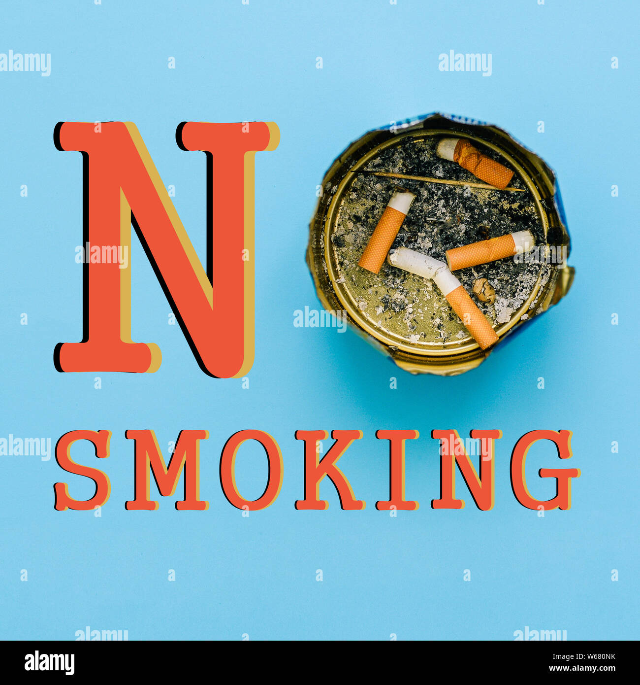 Stop smoking. Ashtray with cigarette butts and ash on a blue background ...