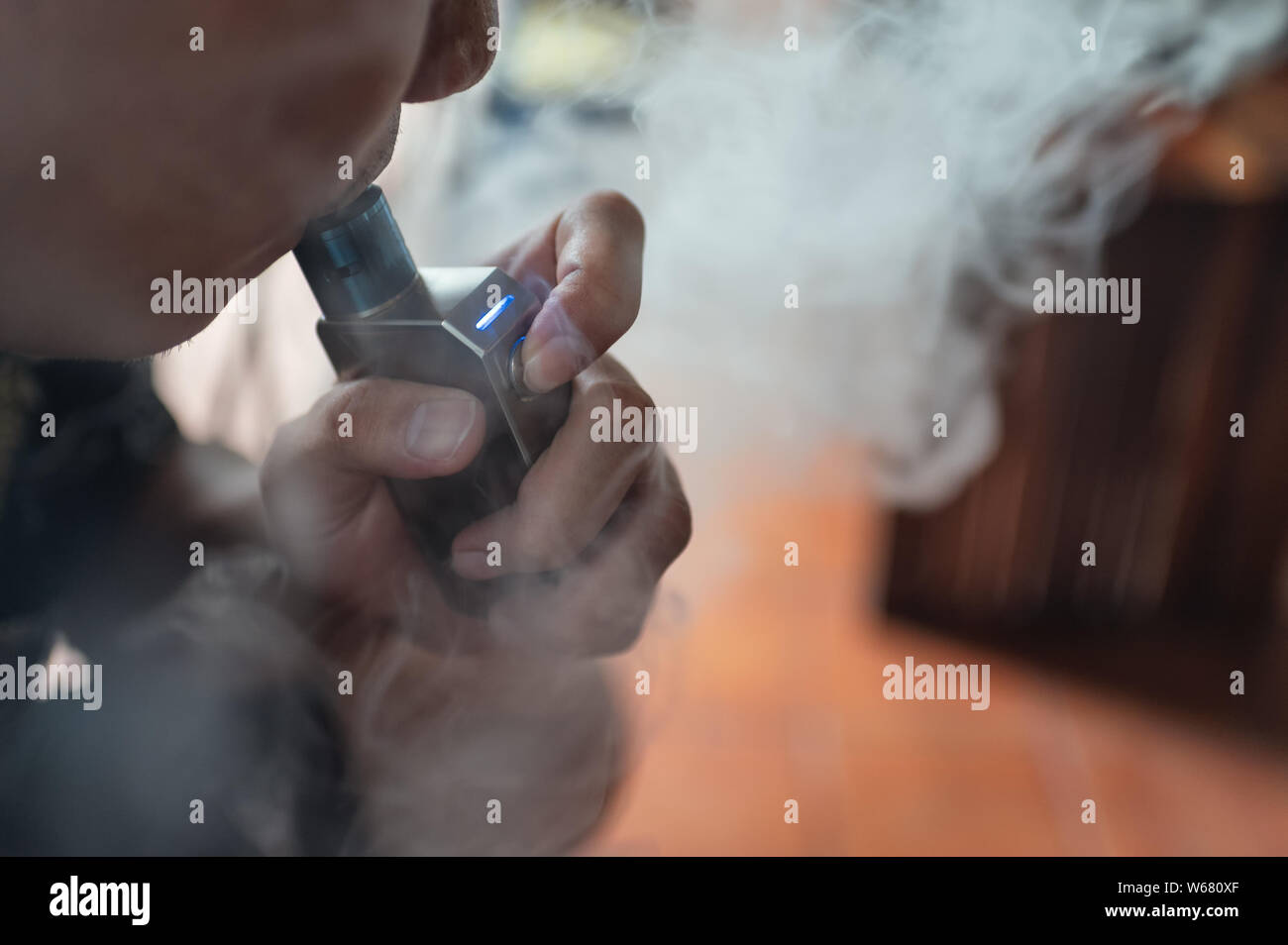 Man vaping of electric cigarette with vapors Stock Photo - Alamy