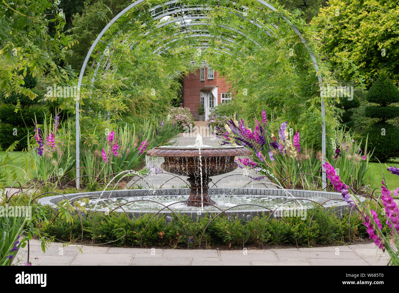 Water feature and wisteria archway at RHS Wisley Gardens, Surrey, UK ...