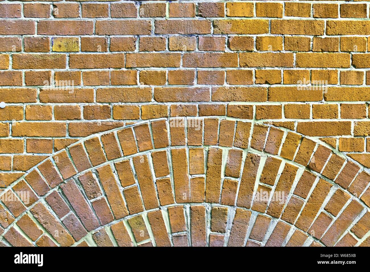 Yellow brick walls with old and weathered stones and cracks im high ...