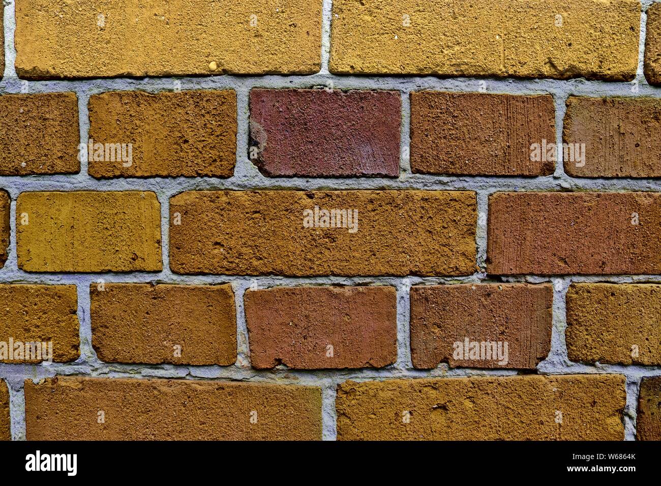 Yellow brick walls with old and weathered stones and cracks im high ...