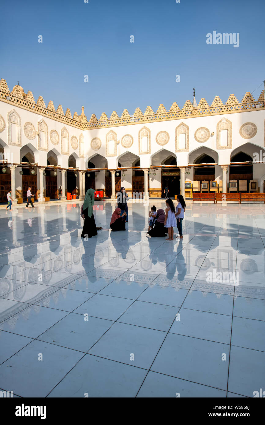 Women and children walking across the marble paved courtyard of the Al ...