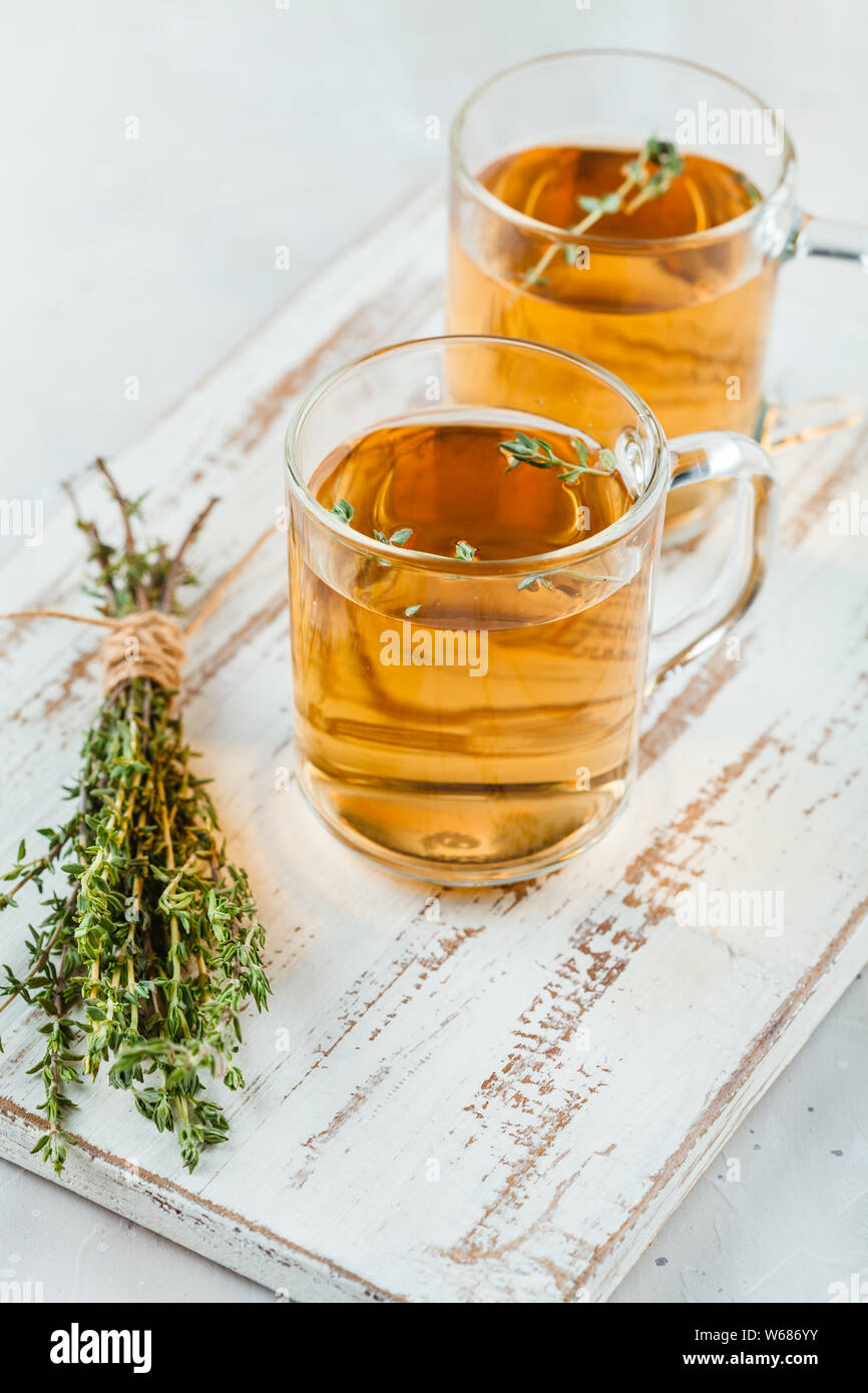 Transparent glasses cup of herbal tea with thyme and sprigs of thyme ...
