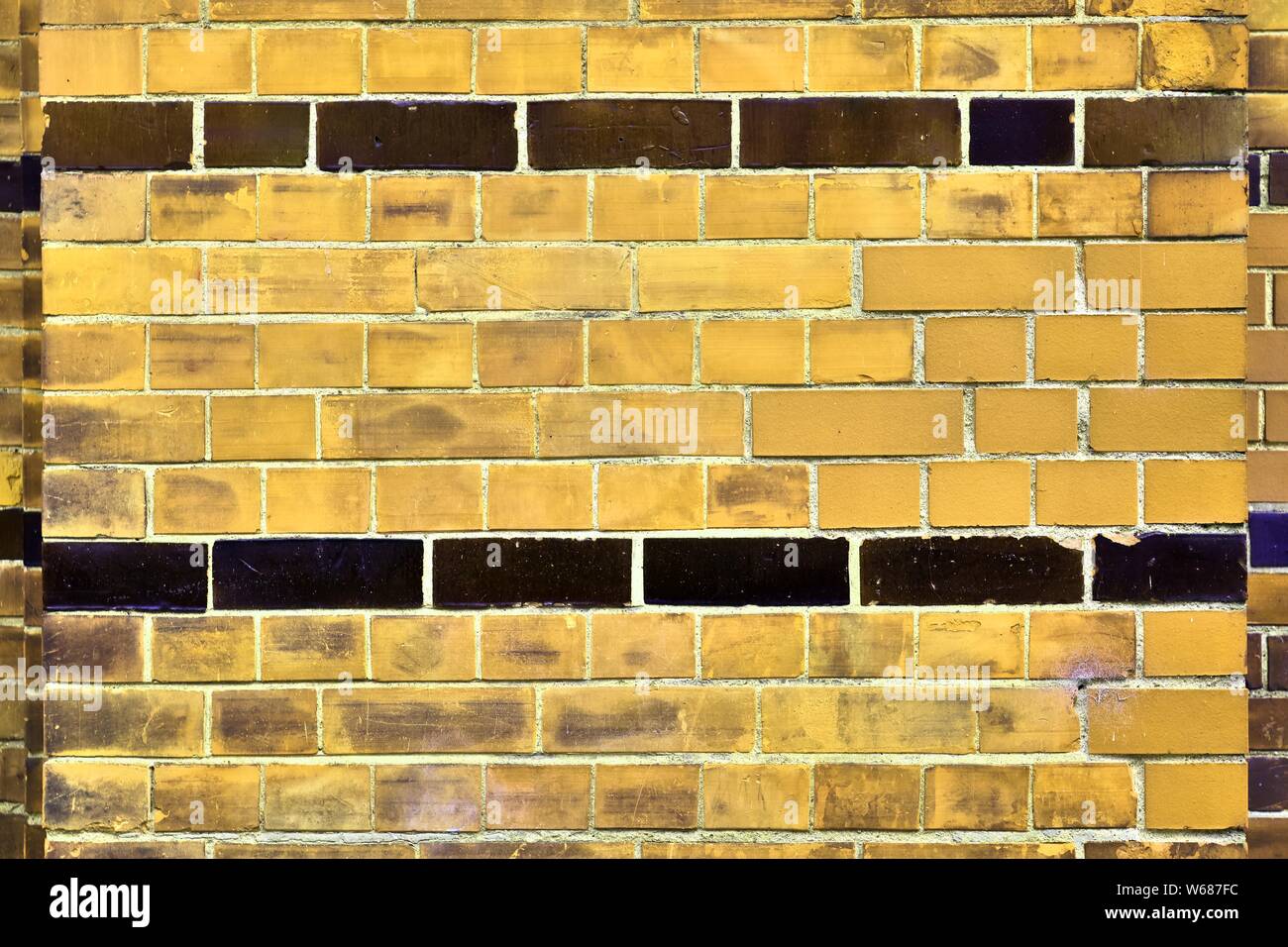 Yellow brick walls with old and weathered stones and cracks im high ...