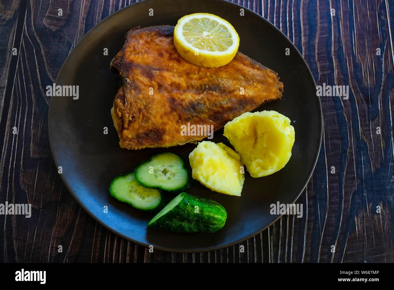 Fried flounder on a plate. Home cooking in a rustic style Stock Photo ...