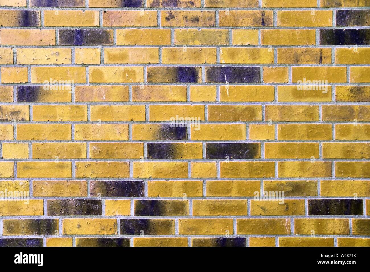 Yellow brick walls with old and weathered stones and cracks im high ...