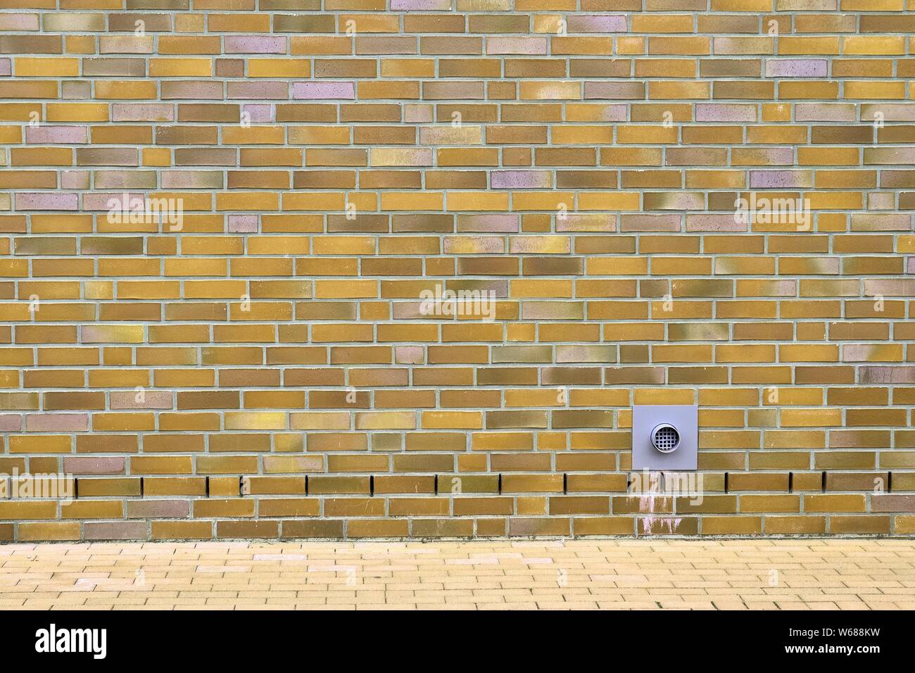 Yellow brick walls with old and weathered stones and cracks im high ...