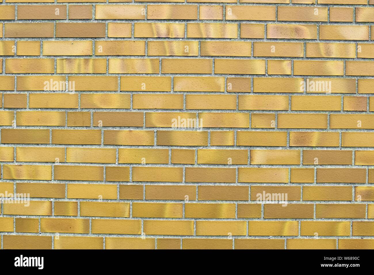 Yellow brick walls with old and weathered stones and cracks im high ...