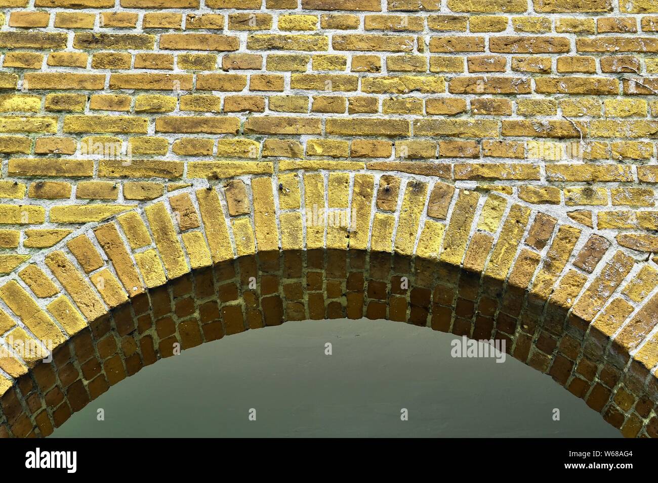 Yellow brick walls with old and weathered stones and cracks im high ...
