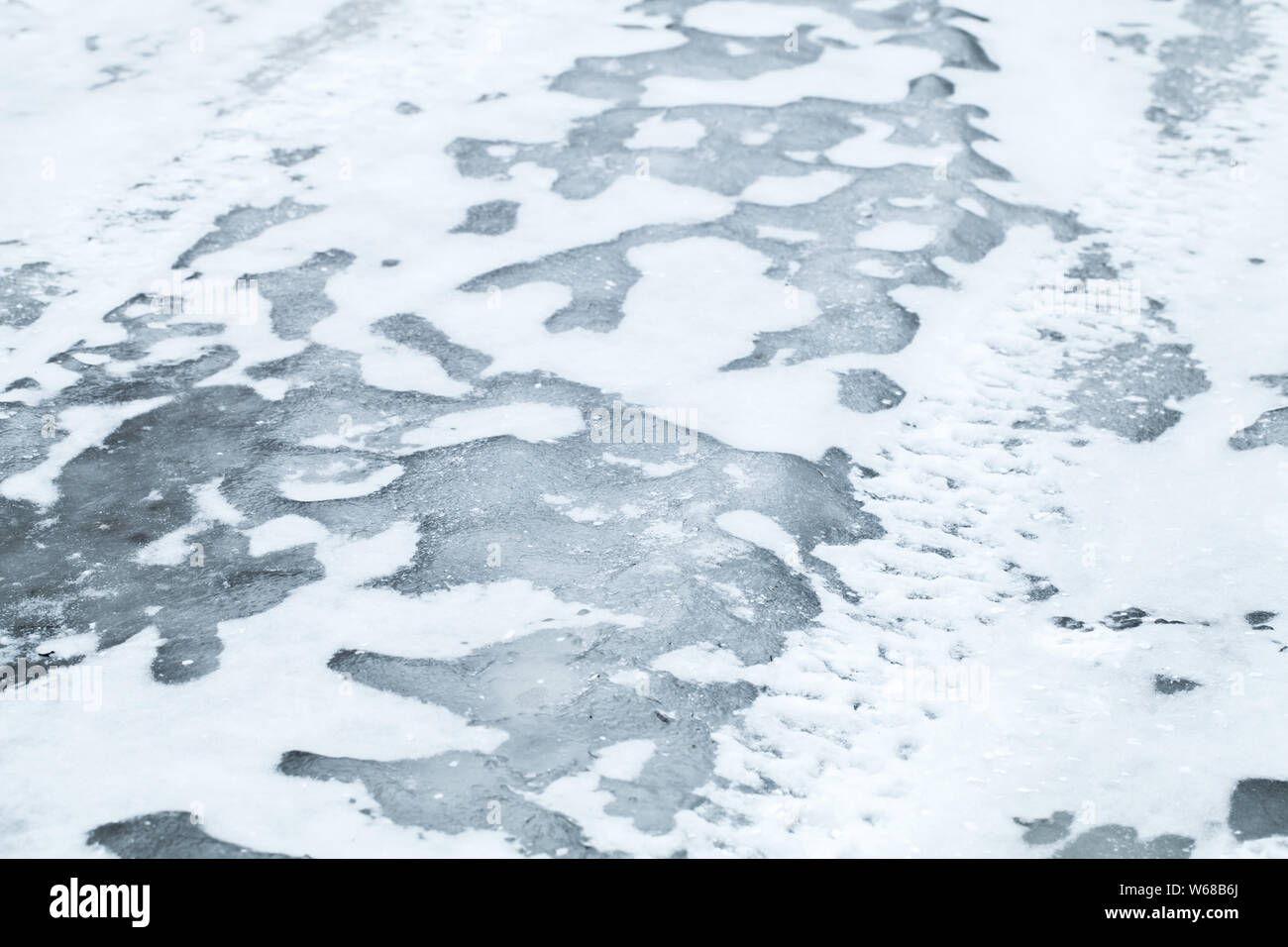 Winter transportation background photo with tire tracks on icy road ...