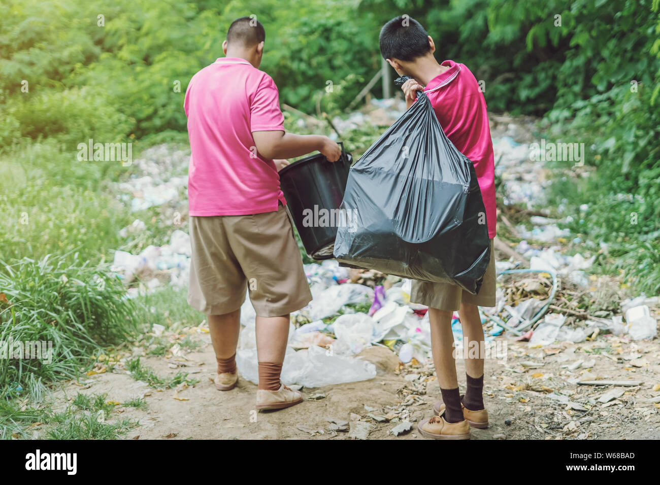 Male Students help to remove rubbish from the classroom to pile waste ...