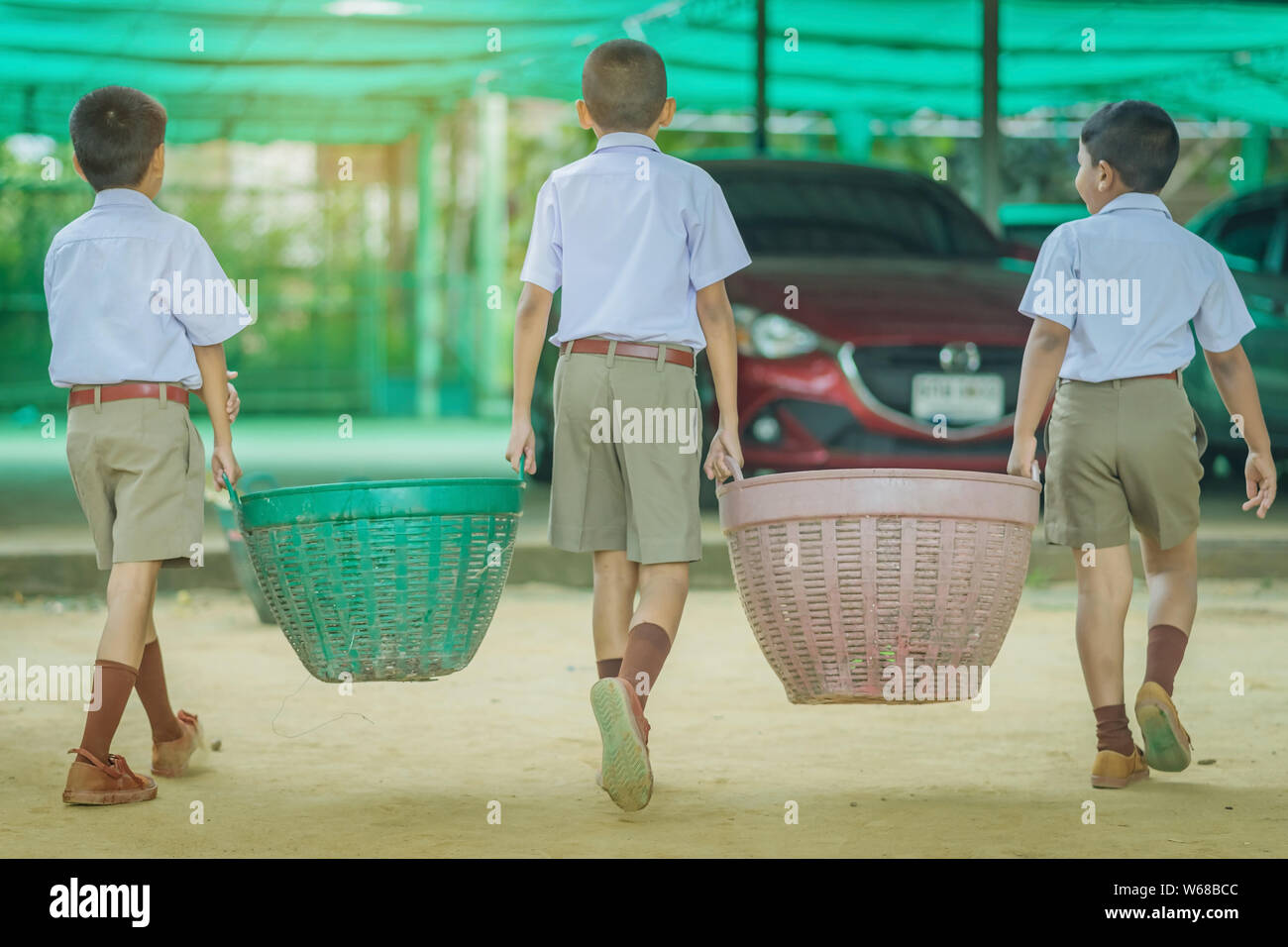 Male Students help to remove rubbish from the classroom to pile waste ...
