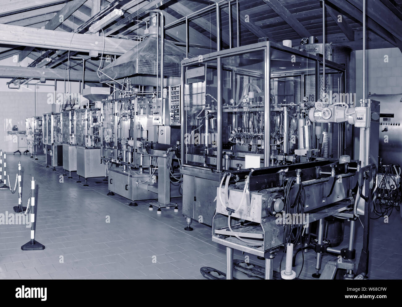 Wine bottling equipment line in a hangar, toned image Stock Photo - Alamy